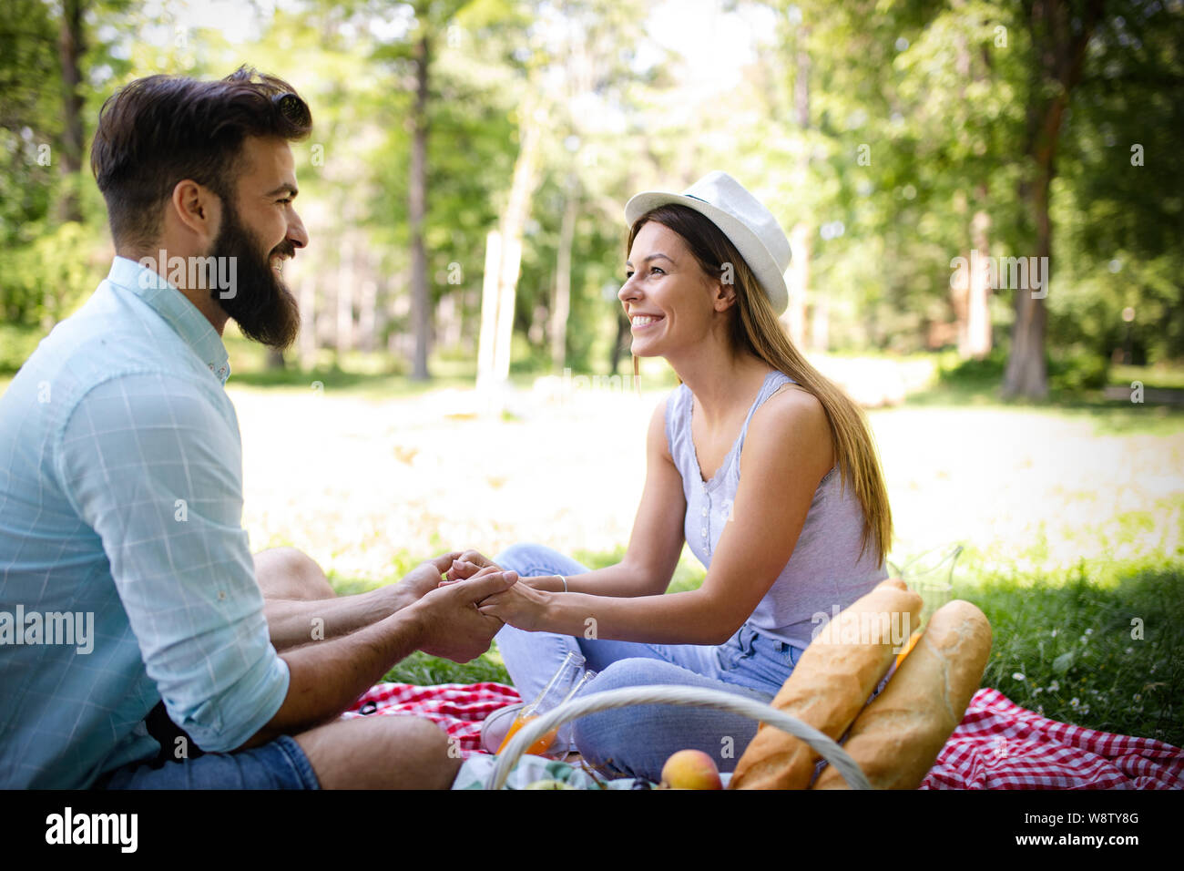 Happy young couple enjoying a picnic in the park together Stock Photo ...