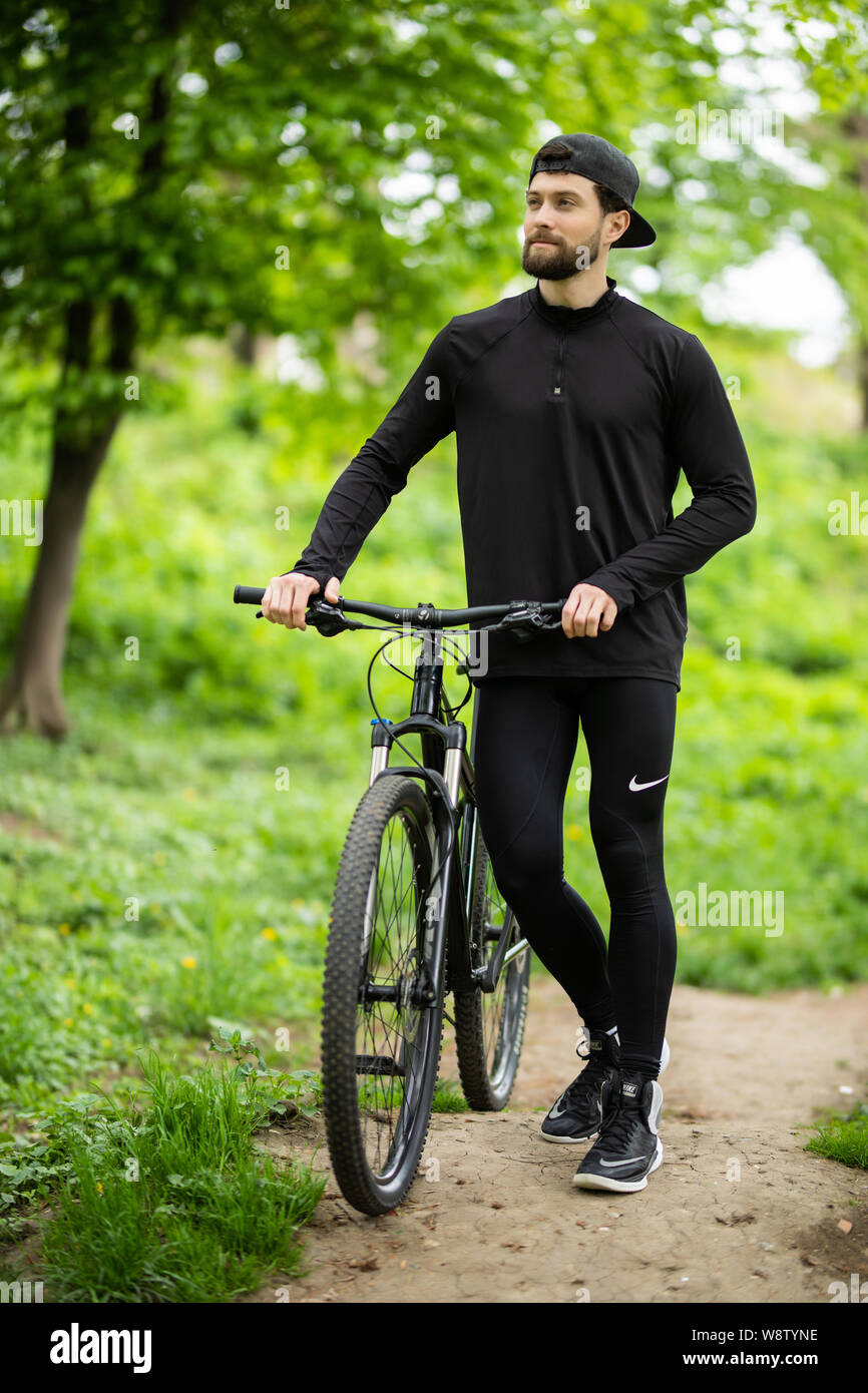 Professional cyclist carrying bicycle while riding off road in the ...