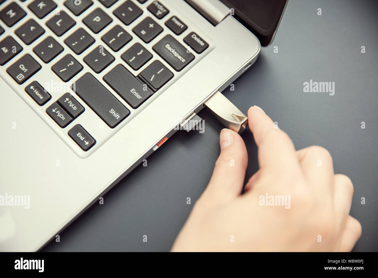 Woman's hand connects design aluminium pendrive to modern ultrabook ...