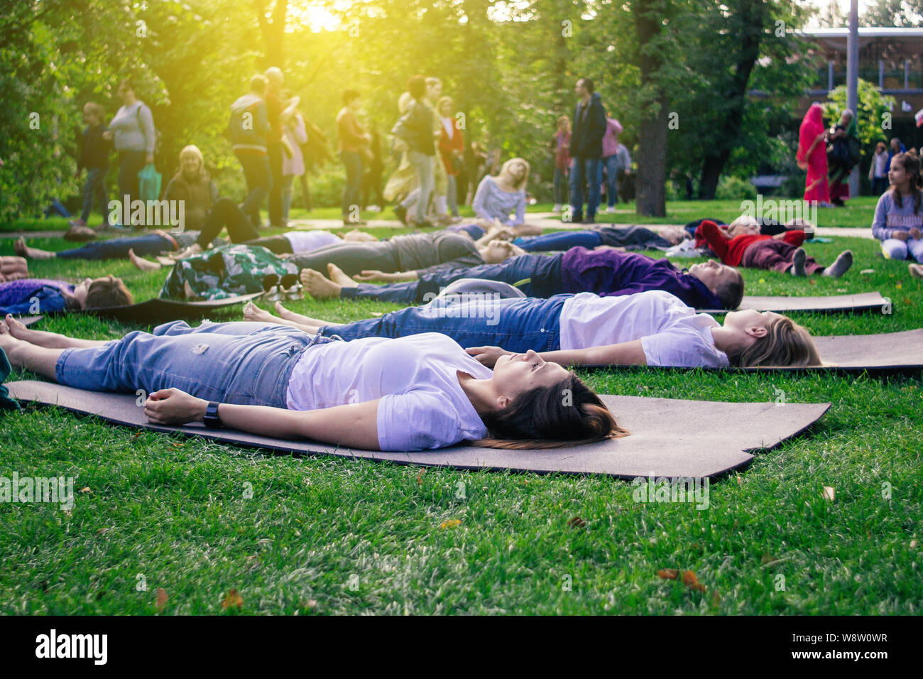 Yoga in the park on summer nature. A group of people are doing yoga ...