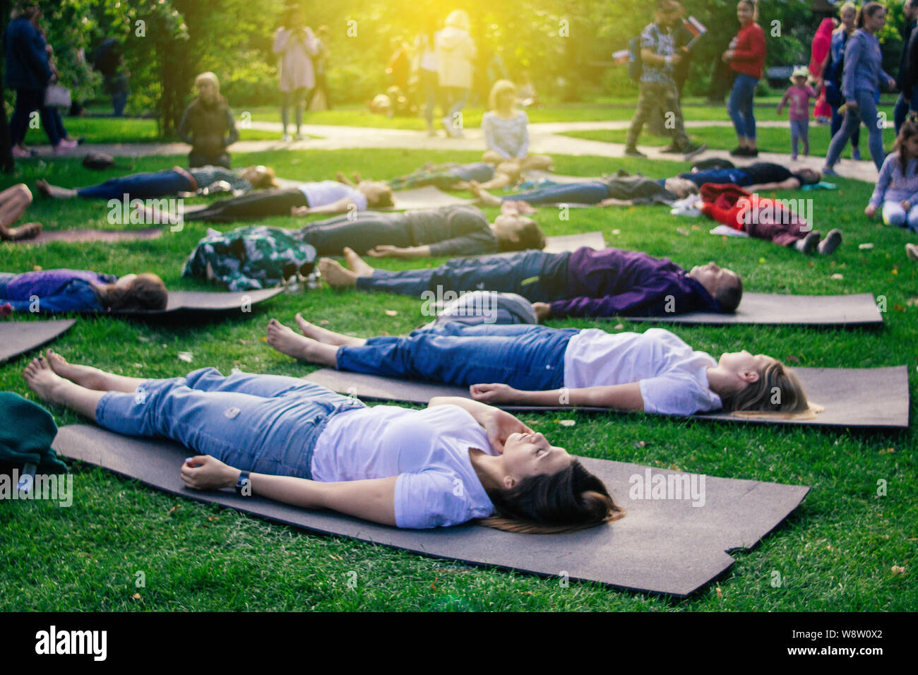 Yoga in the park on summer nature. A group of people are doing yoga ...