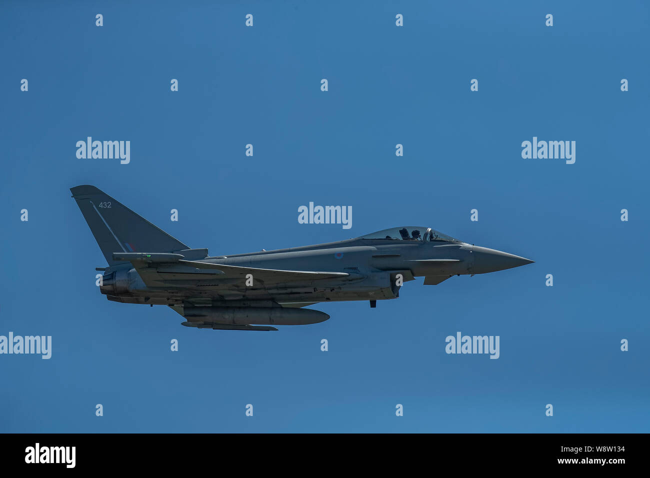 Very fast and noisy RAF Typhoon Fighter Jet in flight with a plain blue ...