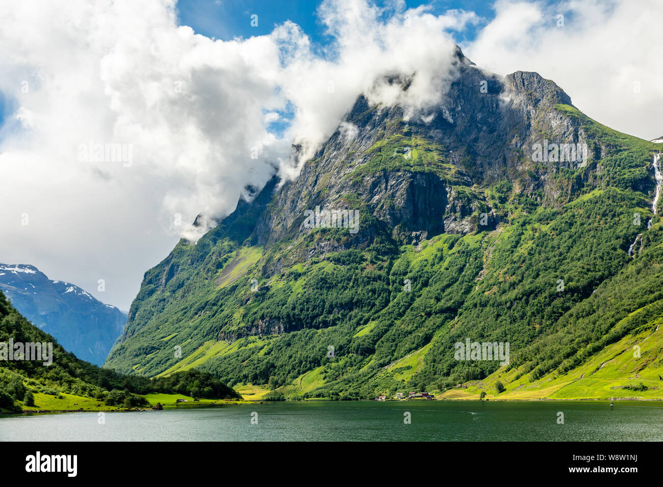 Green mountain peak above the small village in Naeroy fjord, Aurlan ...