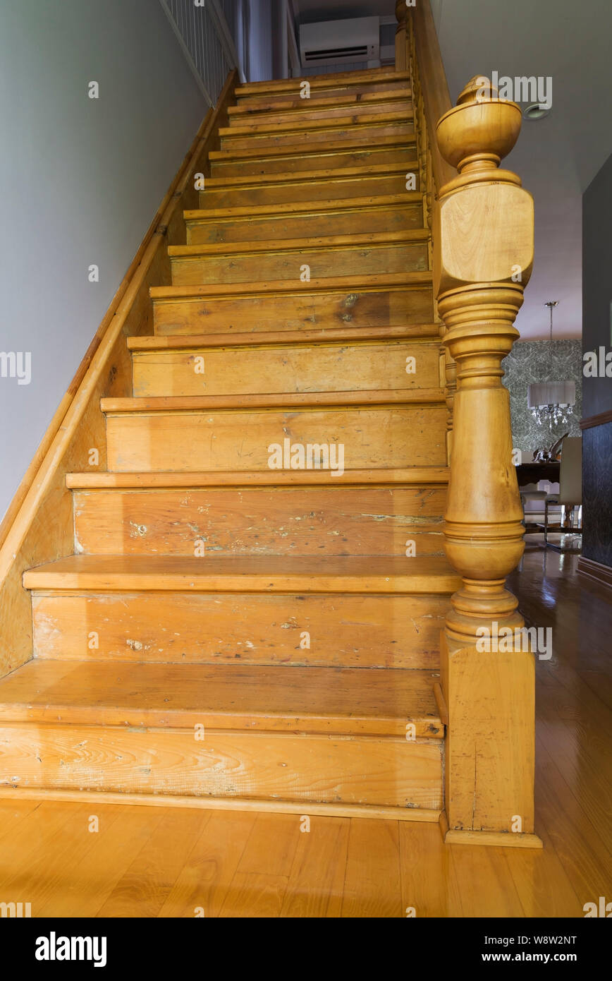 Pinewood post and staircase leading to upstairs floor inside an old ...
