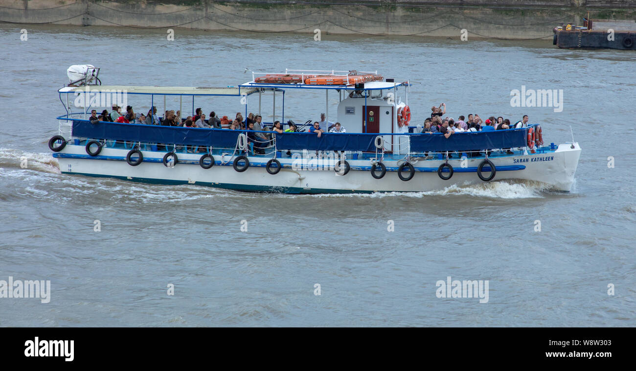 Small tourist boat with tourists on the river Thames on a late ...