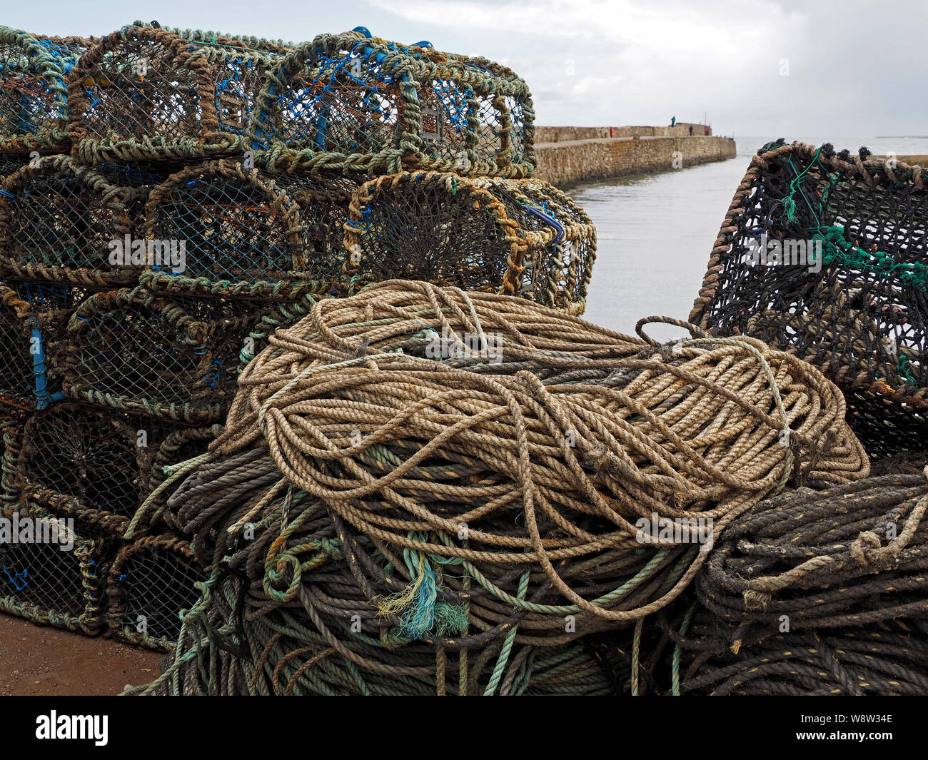 fishermen's ropes and crab/lobster pots beside the harbour wall of the ...