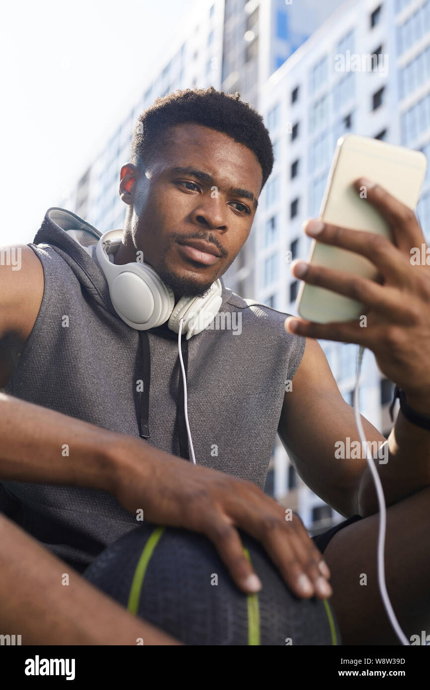 Low angle portrait of contemporary African-American man using ...