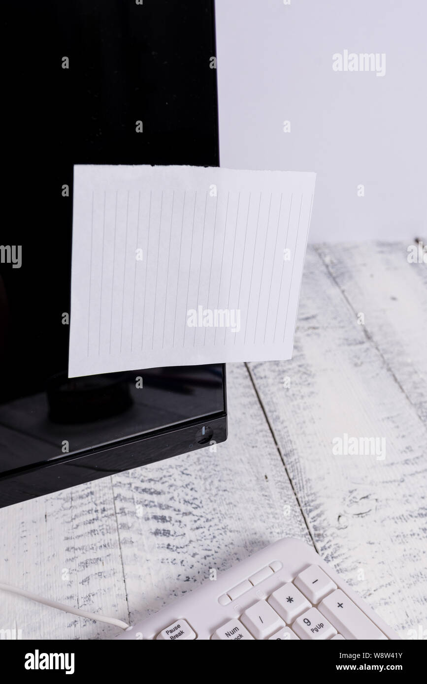 Notation paper taped to black computer monitor screen near white ...