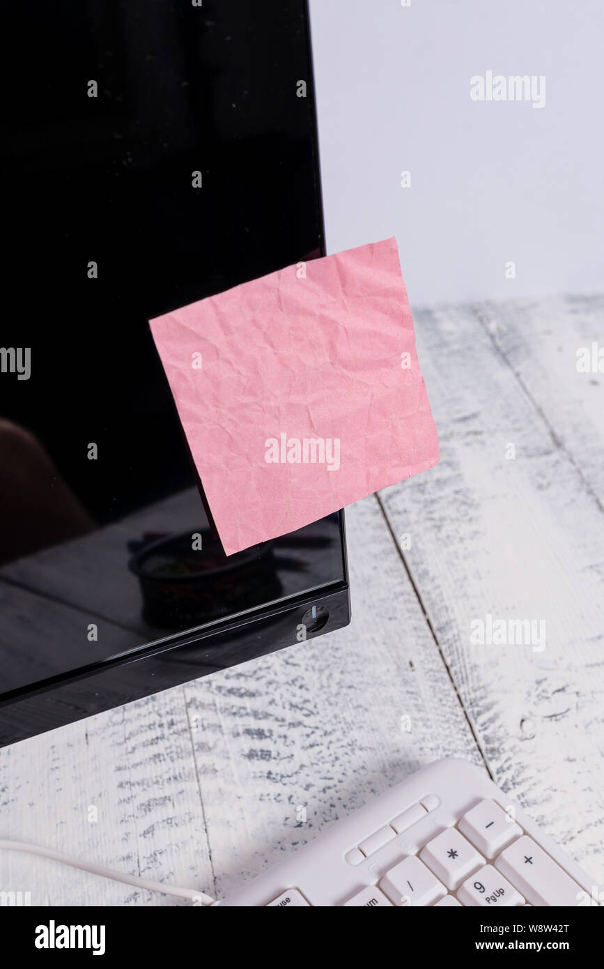 Notation paper taped to black computer monitor screen near white ...