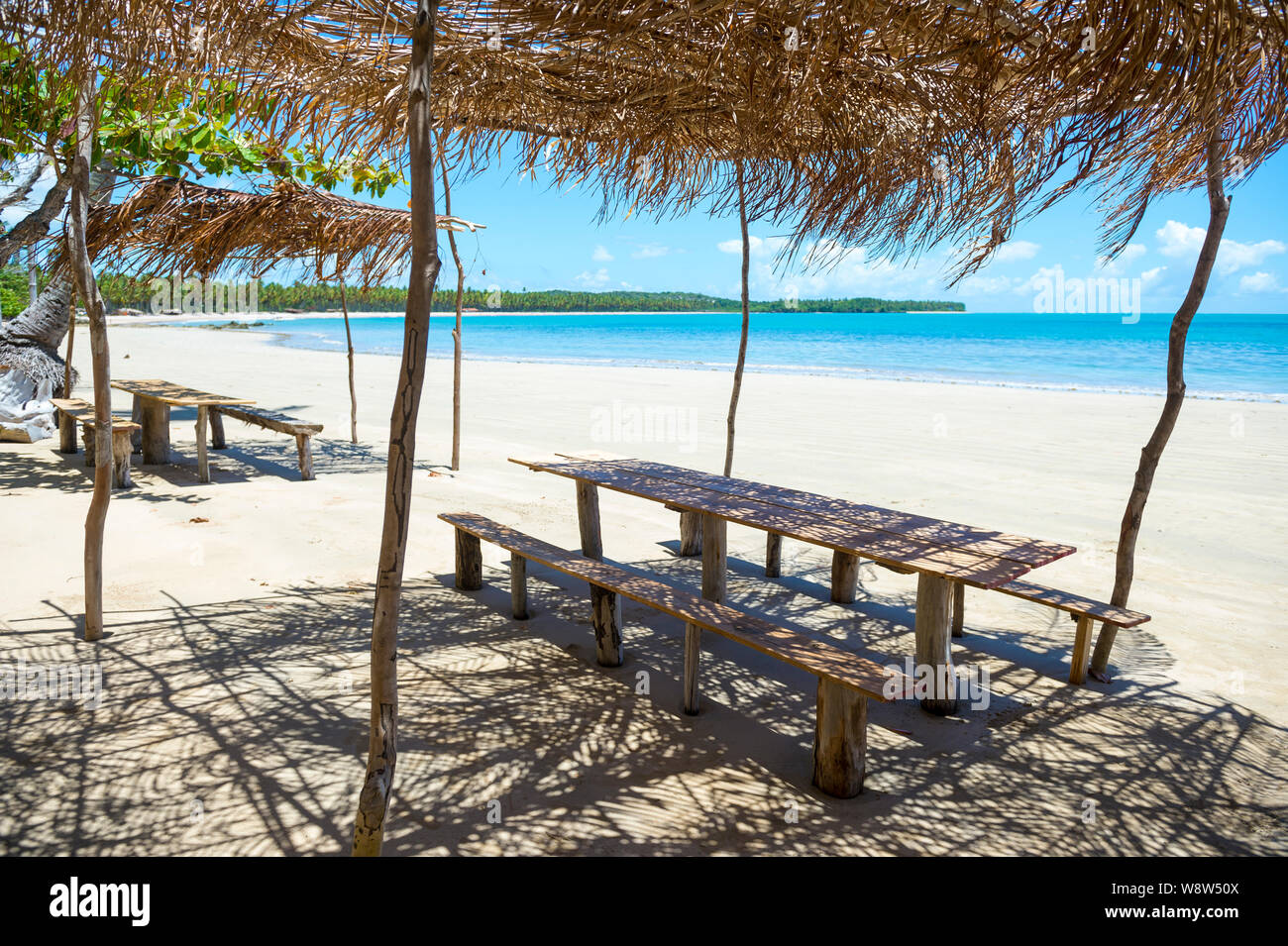 Bright scenic view of wooden picnic tables under rustic Brazilian ...