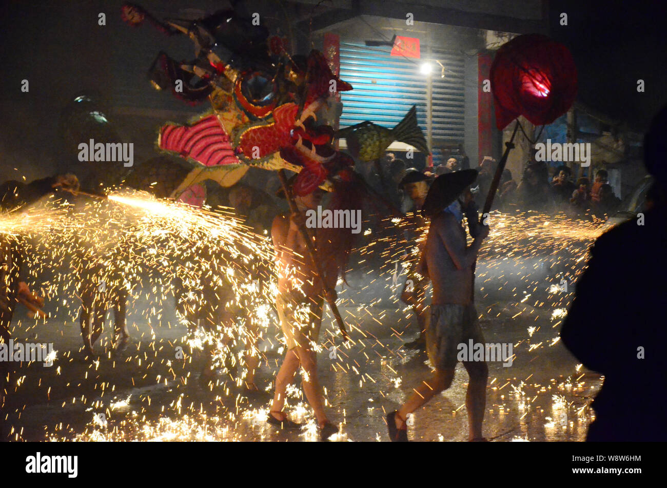 Chinese entertainers perform a fire dragon dance in sparks of fireworks ...
