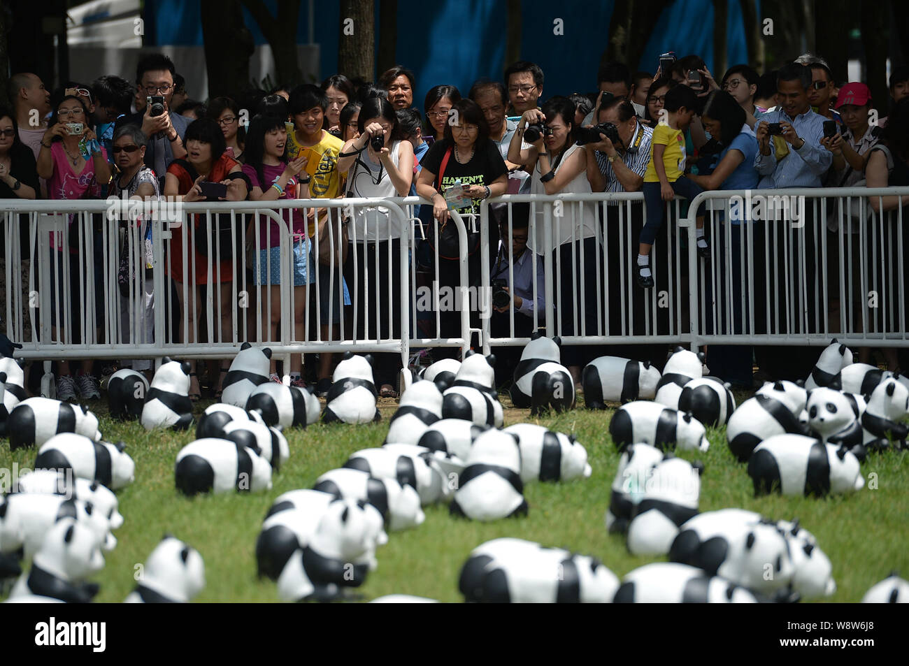 Visitors take photos of the paper pandas created by French artist Paulo ...