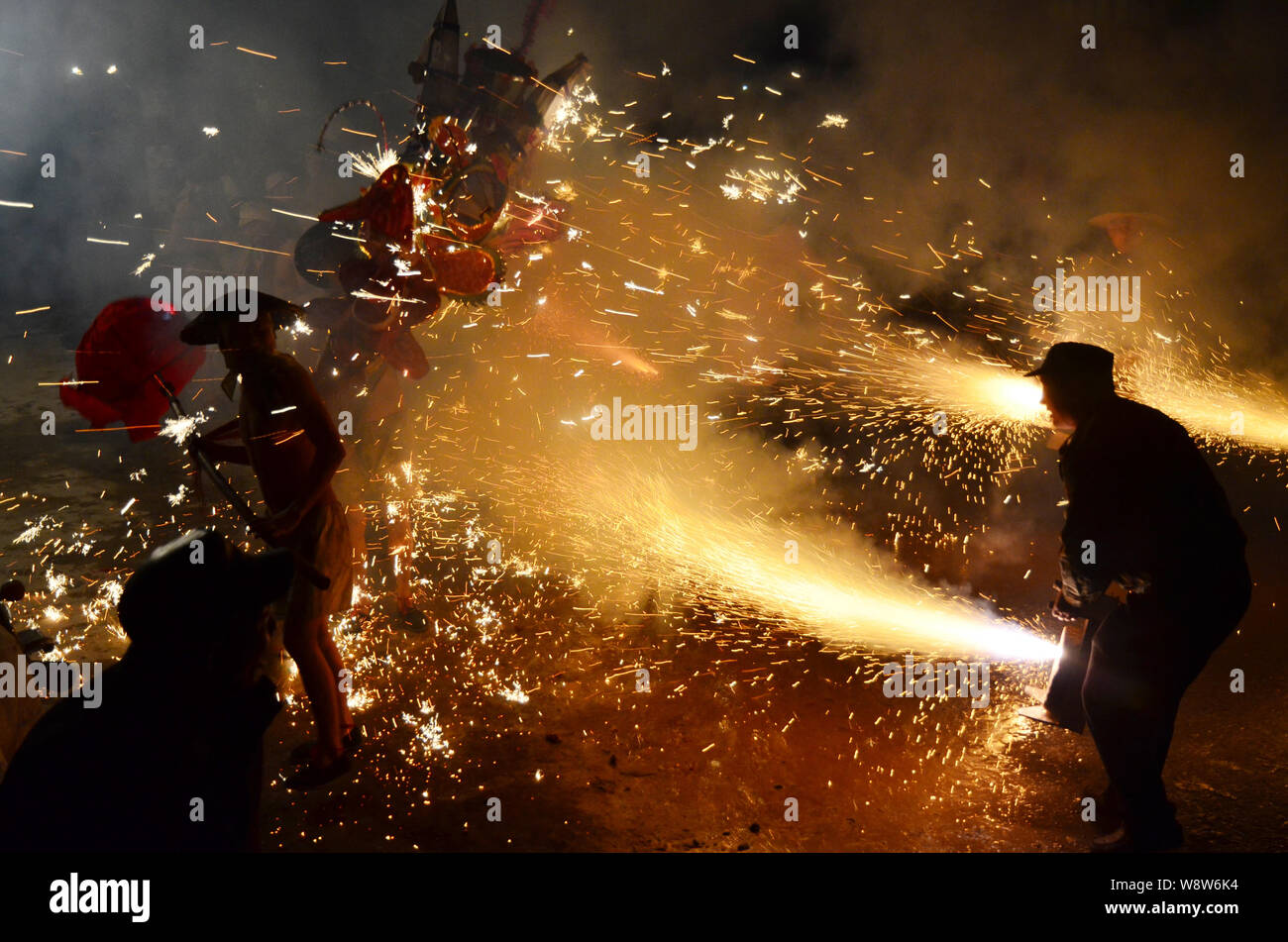 Chinese entertainers perform a fire dragon dance in sparks of fireworks ...