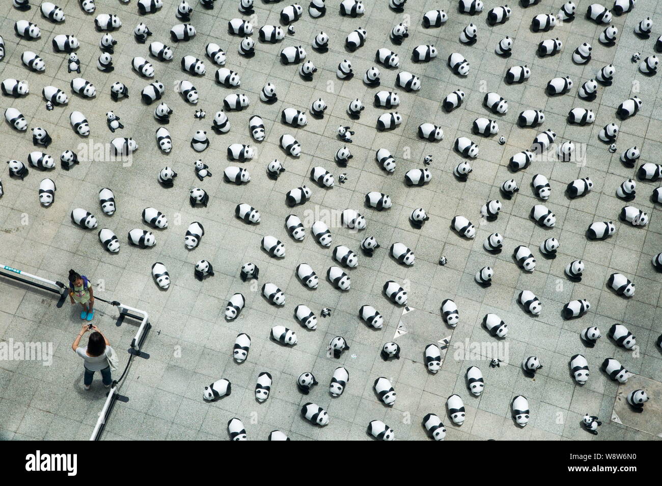 Visitors take photos of the paper pandas created by French artist Paulo ...