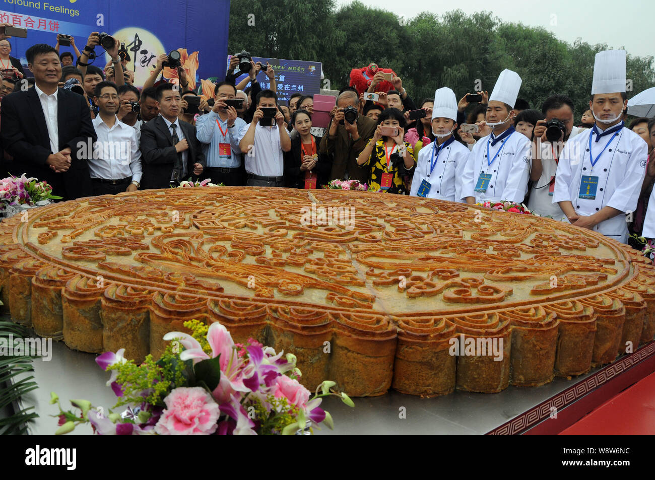 Visitors take photos of the world's largest lily mooncake during an ...