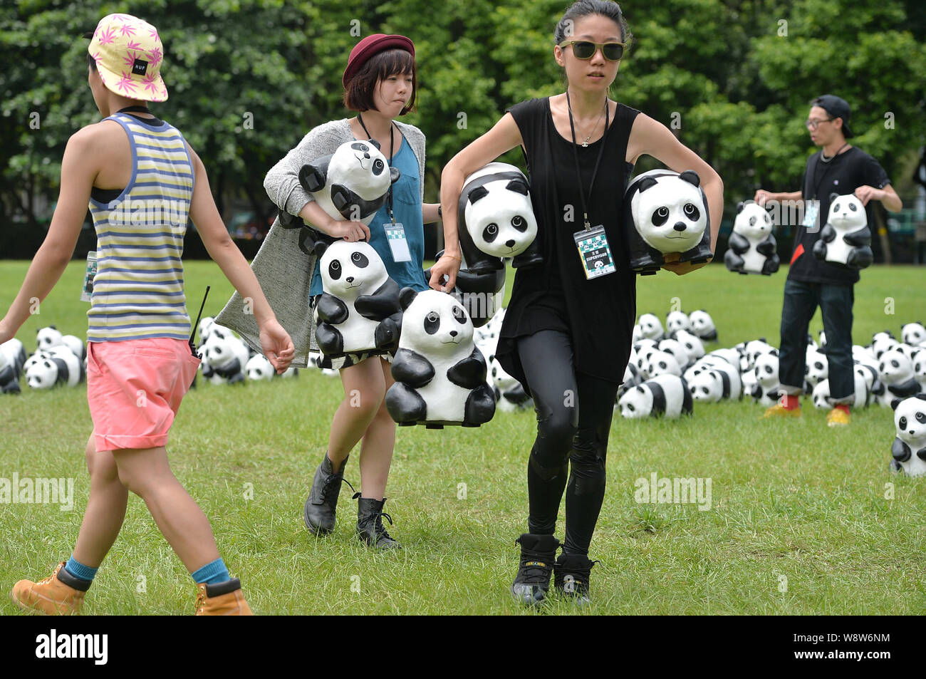 Staff members put the paper pandas created by French artist Paulo ...