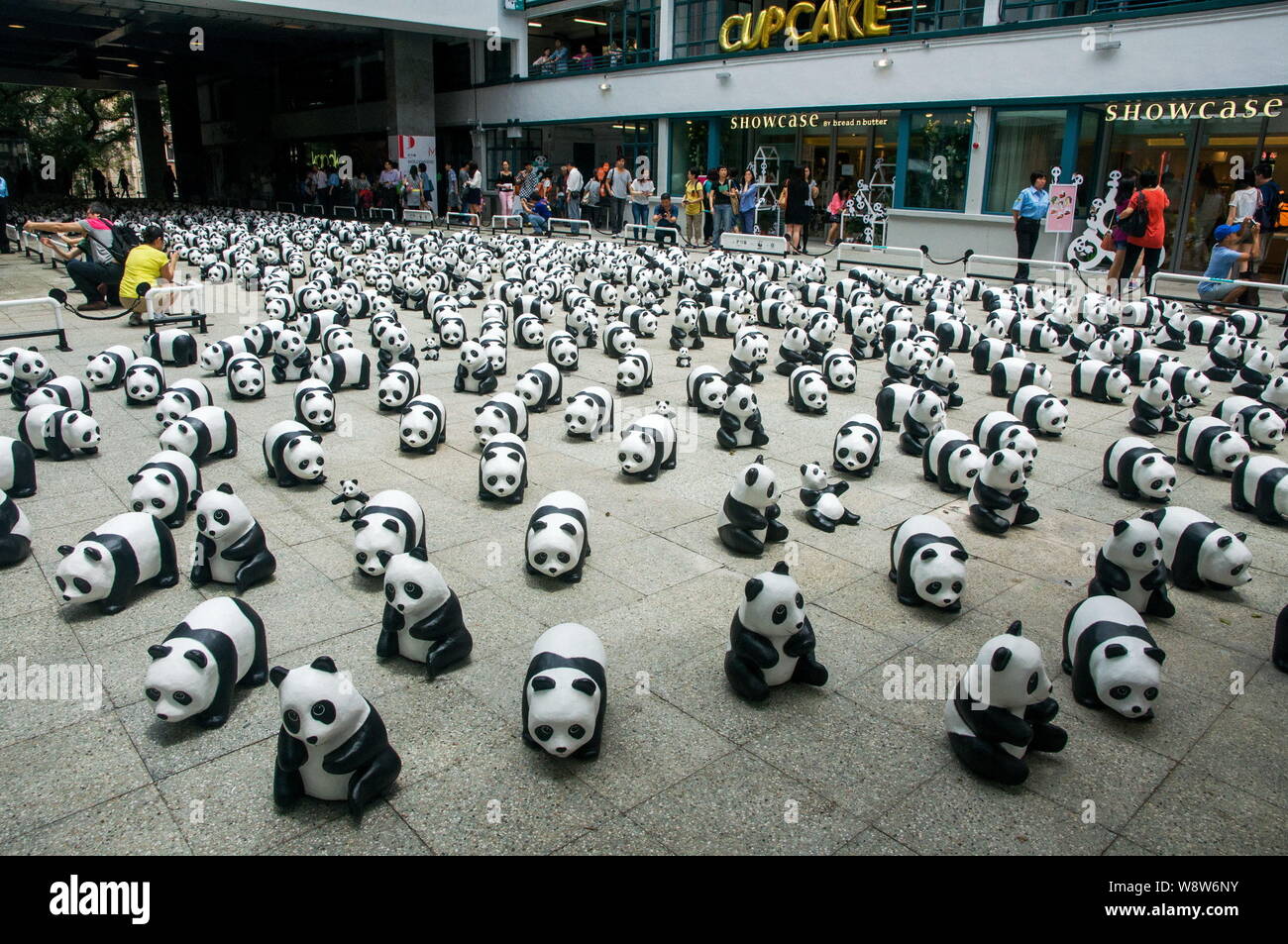 Visitors take photos of the paper pandas created by French artist Paulo ...