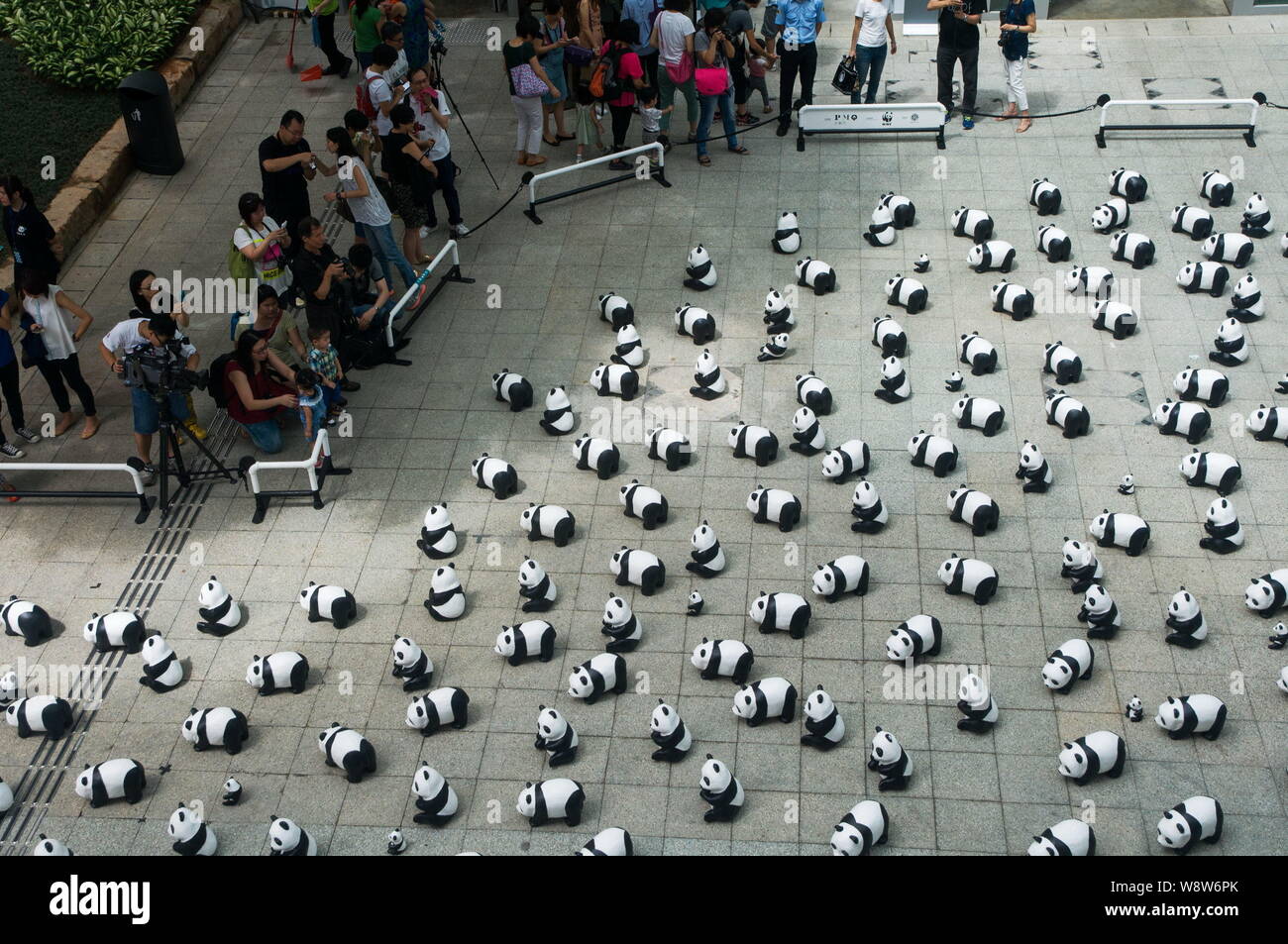 Visitors look at the paper pandas created by French artist Paulo ...