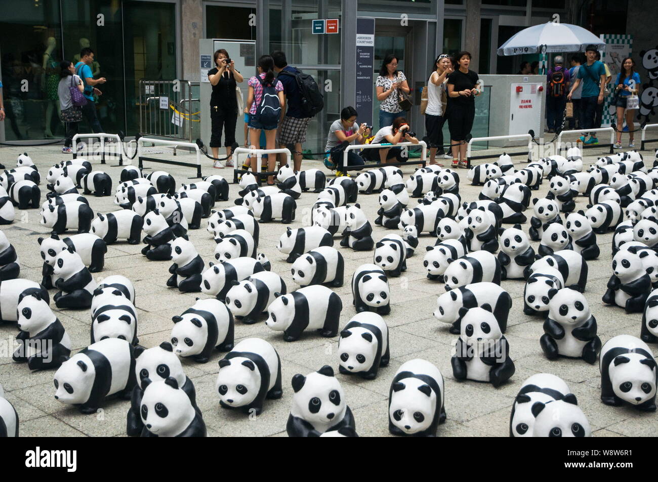 Visitors take photos of the paper pandas created by French artist Paulo ...