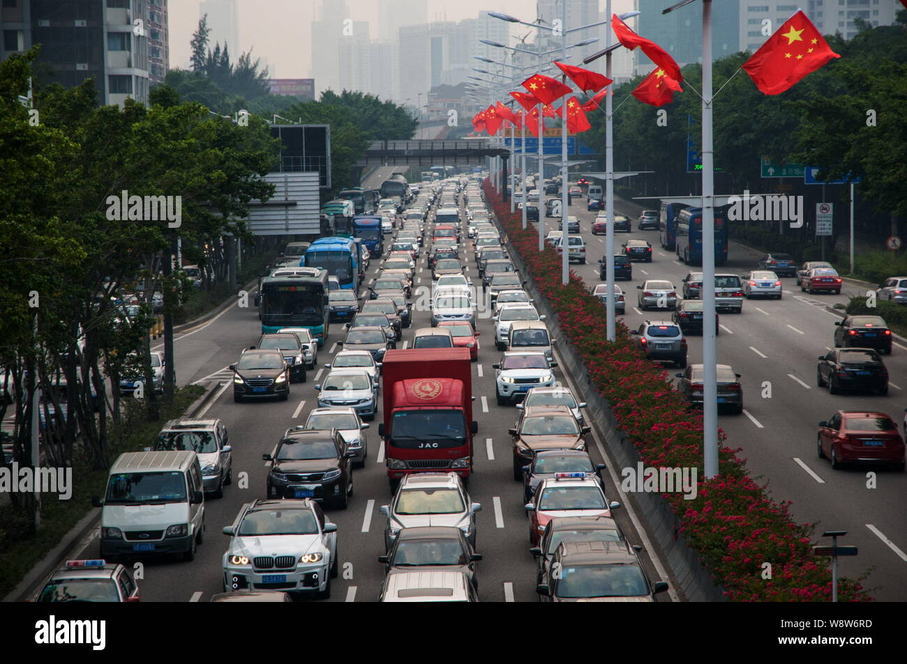 Masses of vehicles move slowly in a traffic jam on a road decorated ...