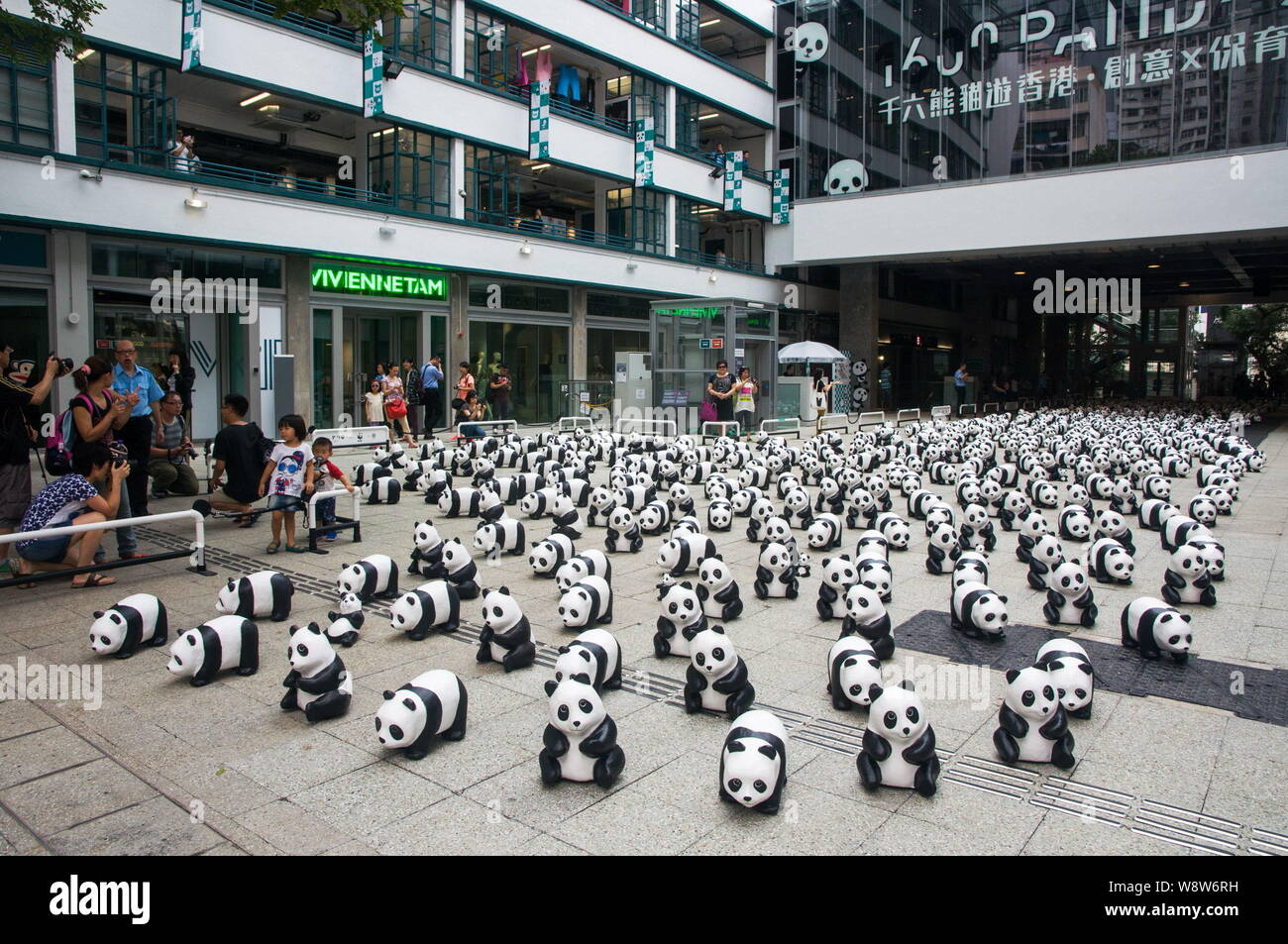 Visitors take photos of the paper pandas created by French artist Paulo ...
