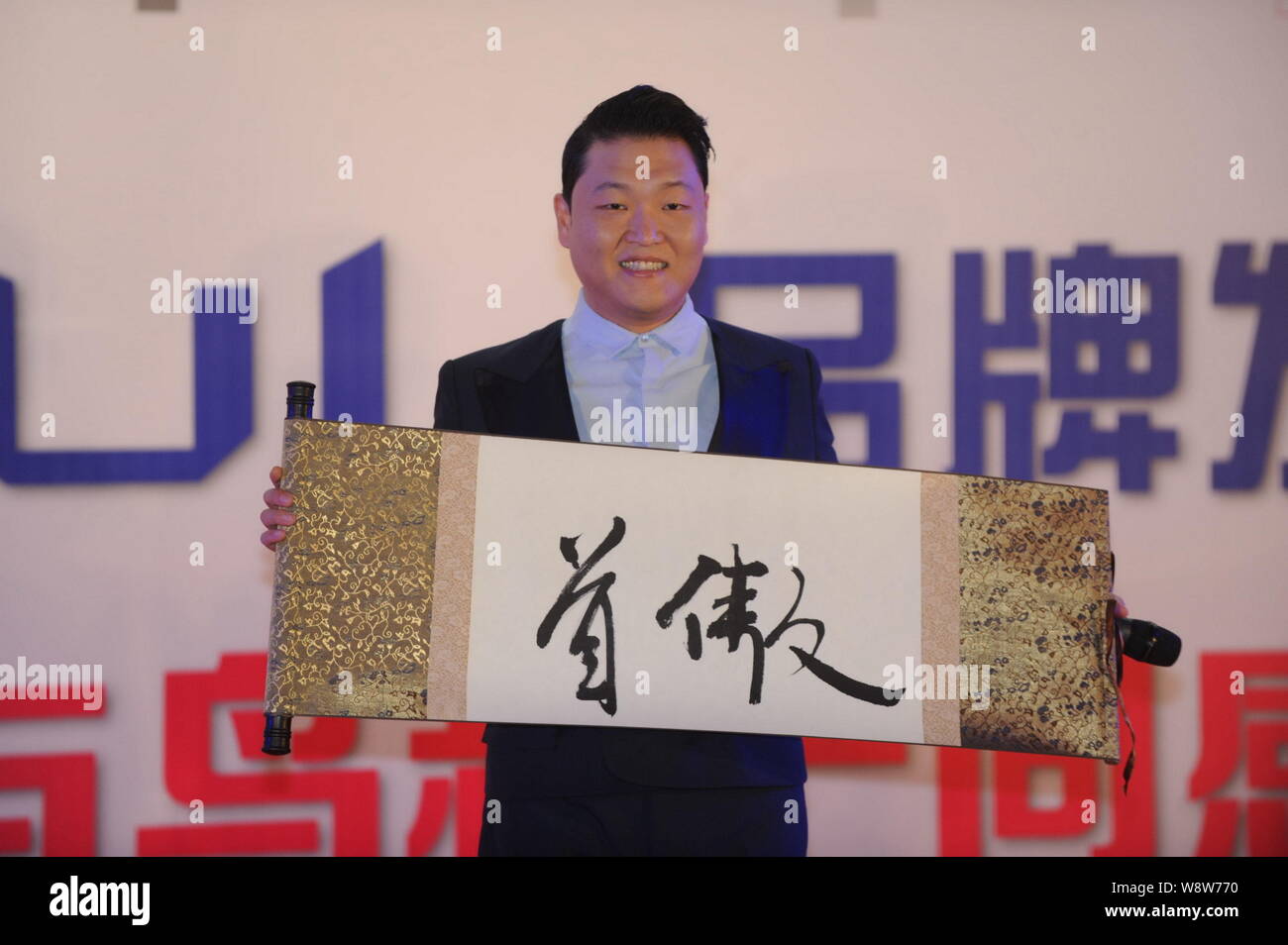 South Korean rapper PSY poses with a calligraphy during a promotional ...