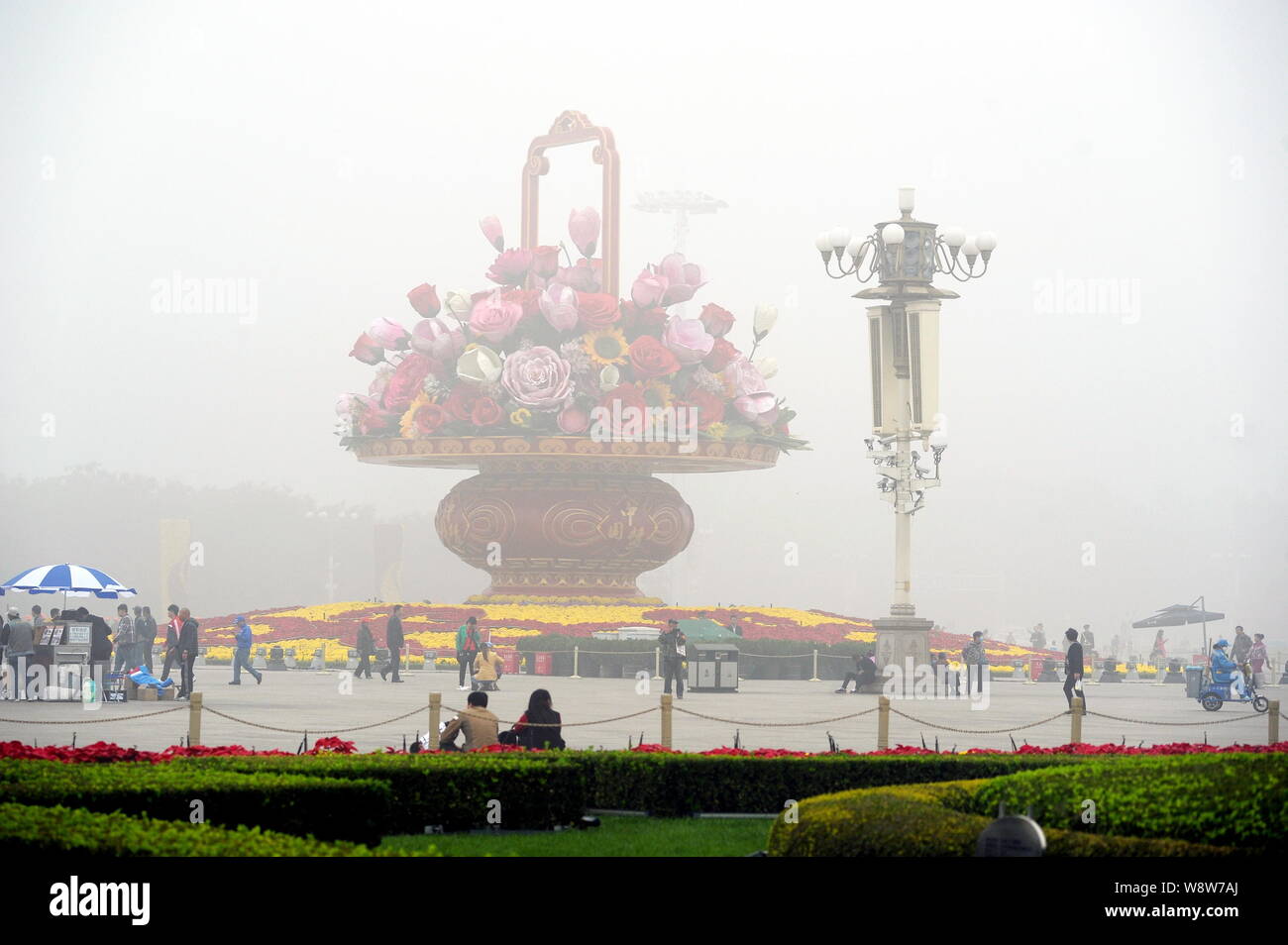 Tourists visit the Tian'anmen Square in heavy smog in Beijing, China ...