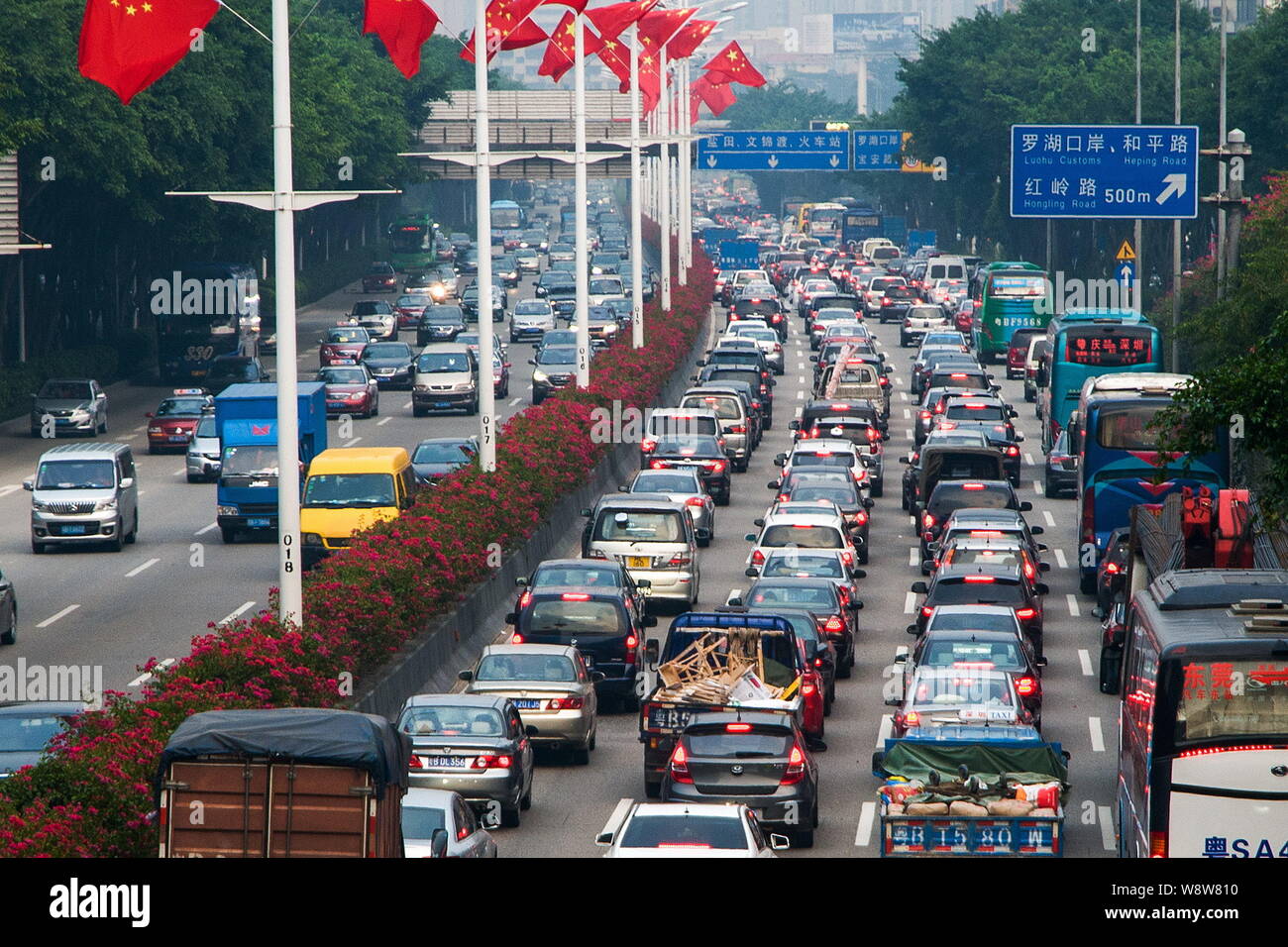 Masses of vehicles move slowly in a traffic jam on a road decorated ...