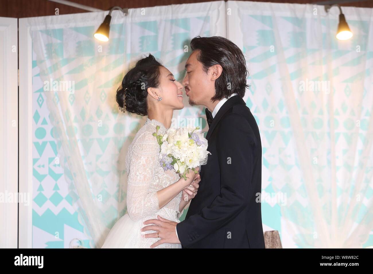 Malaysian singer Penny Tai, left, kisses her Taiwanese husband Sidney Lu ahead of their wedding ...