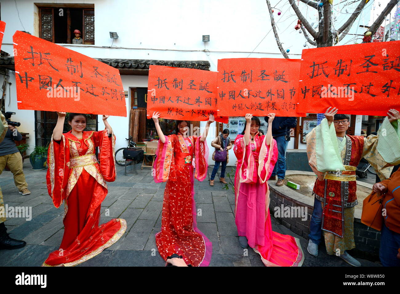 College students wearing traditional Chinese clothing hold slogans in a ...