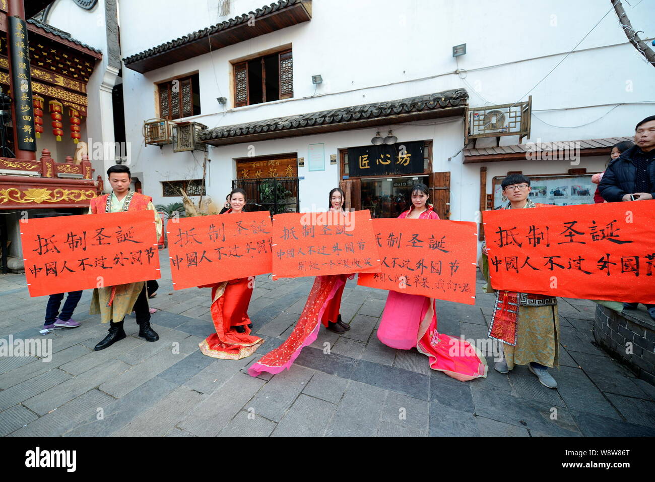 College students wearing traditional Chinese clothing hold slogans in a ...