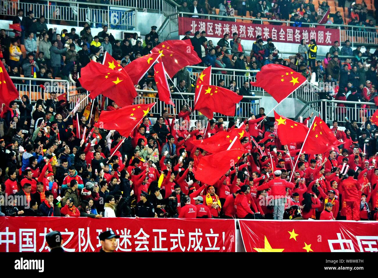 Chinese football fans wave Chinese national flags during the 2014 CFA ...
