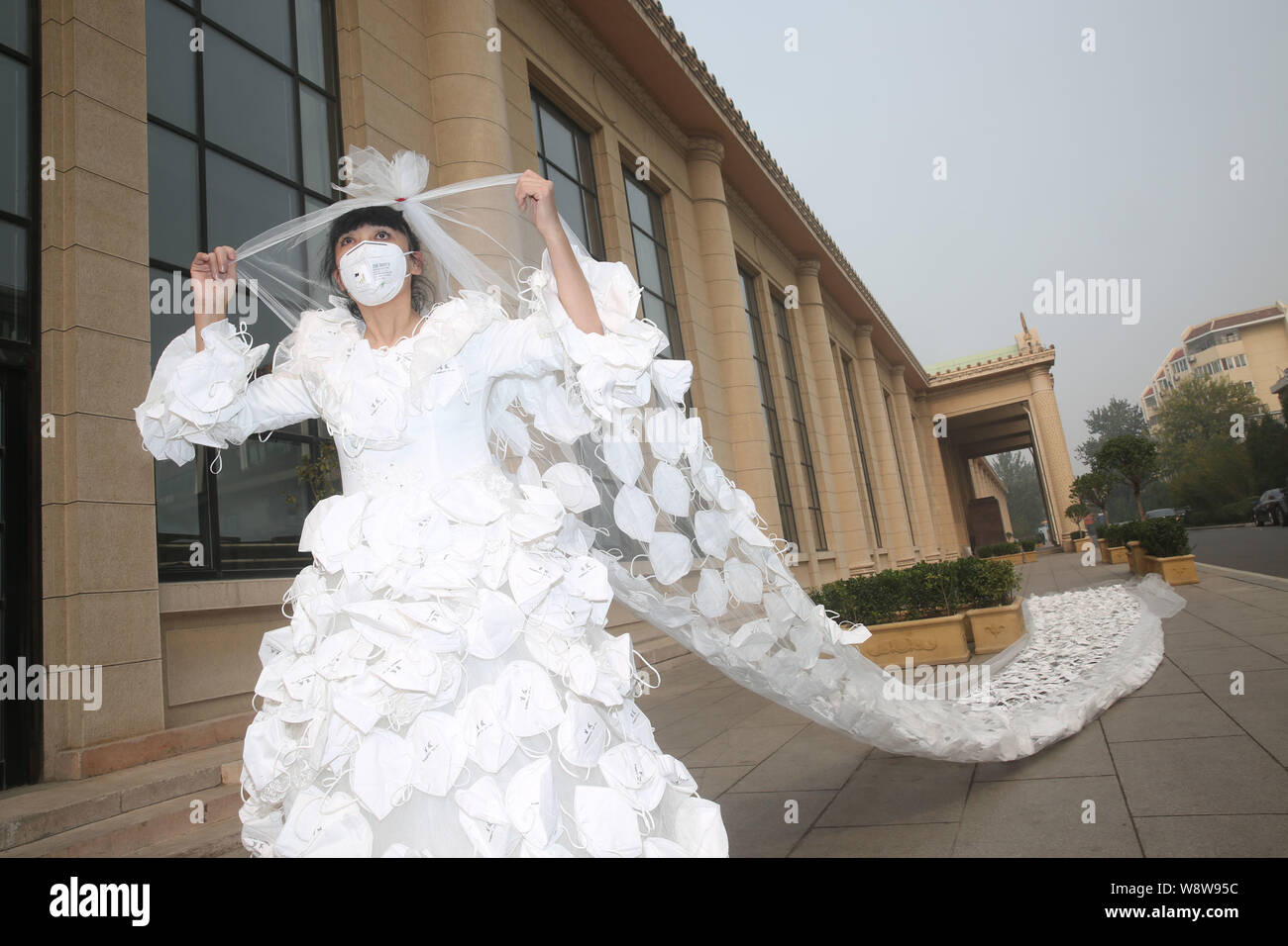 Chinese artist Kong Ning dressed in a 10-meter-long wedding gown made ...