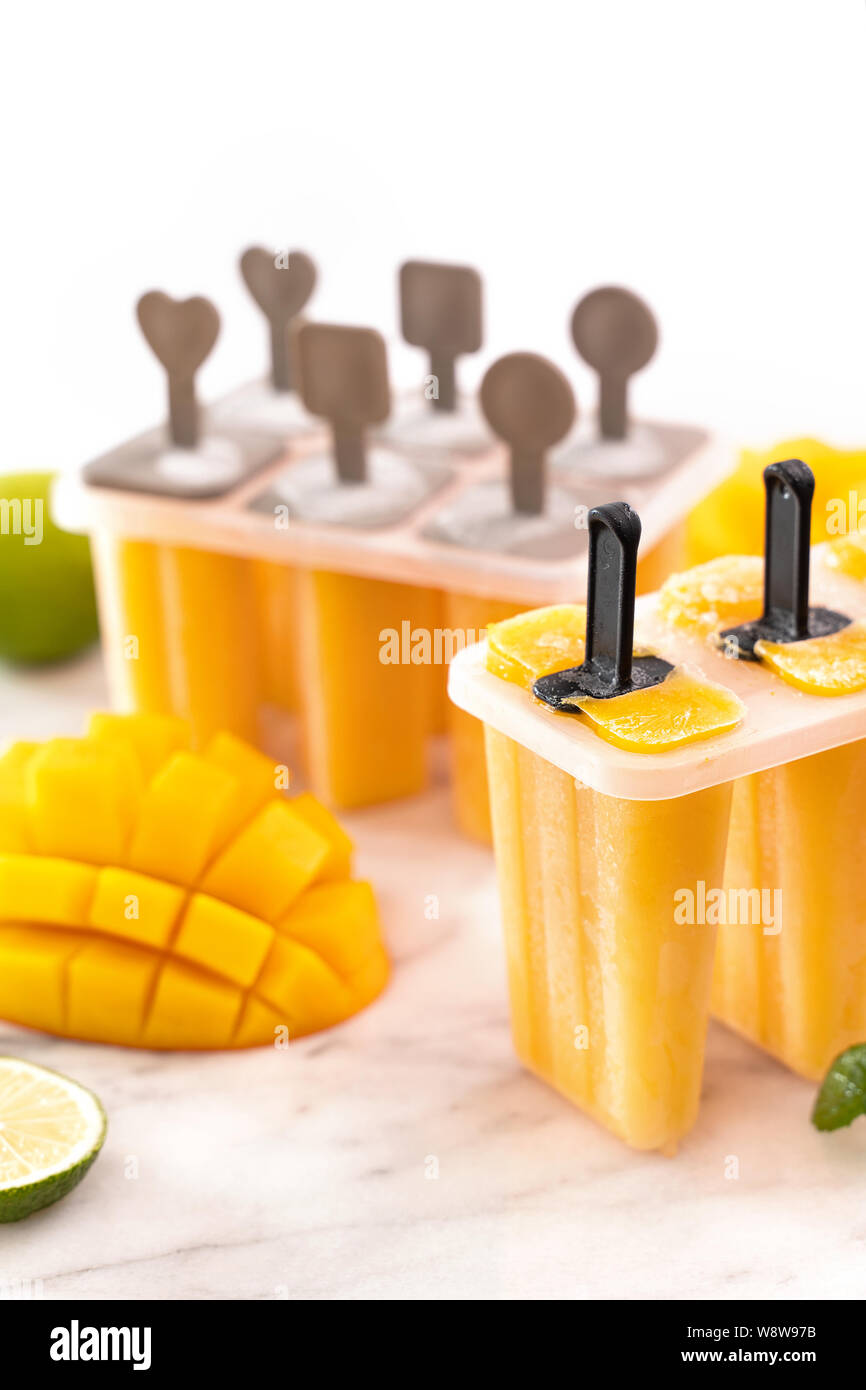 Fresh mango fruit popsicle ice in the plastic shaping box on bright ...