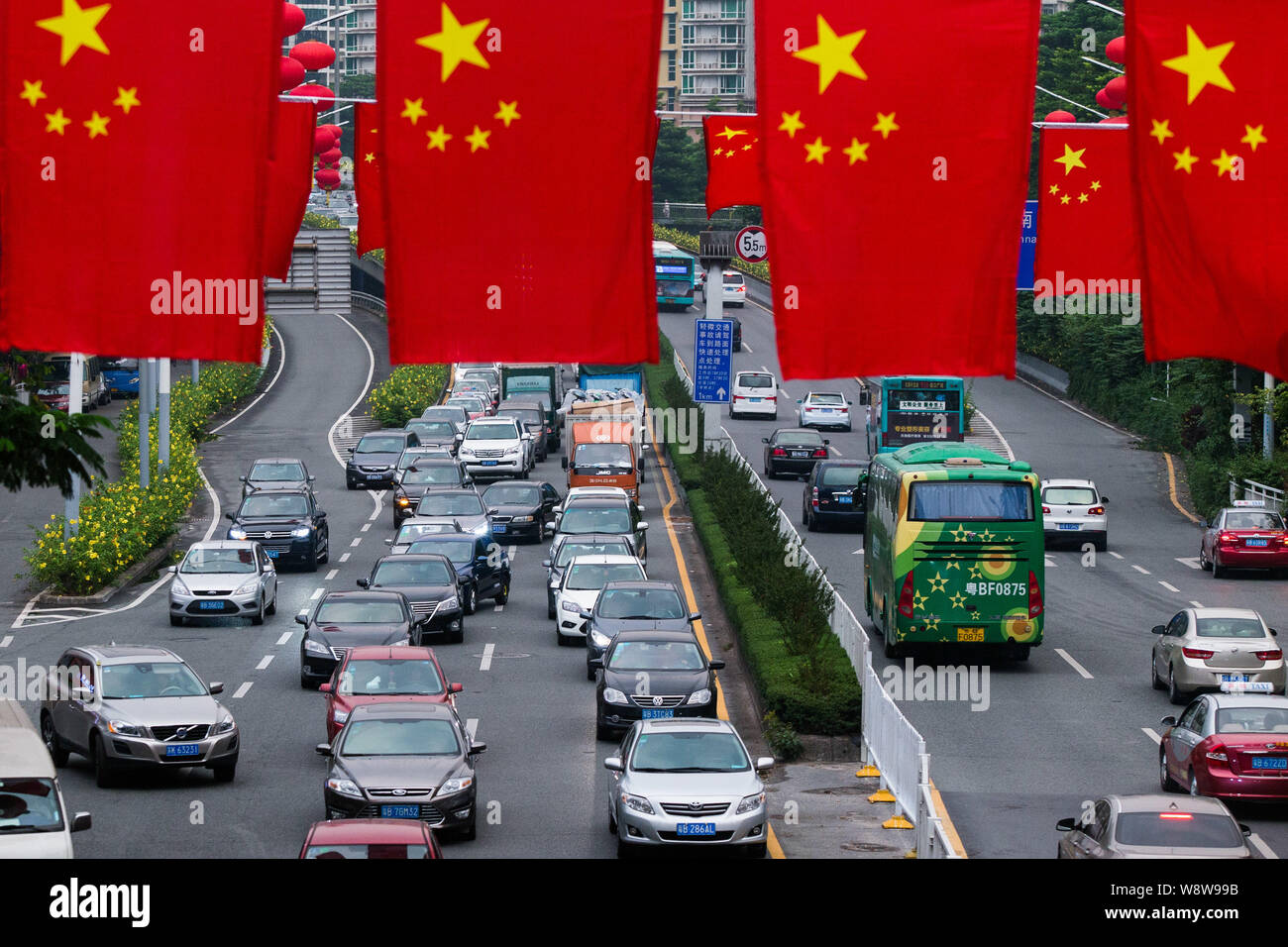 Masses of vehicles move slowly in a traffic jam on a road decorated ...