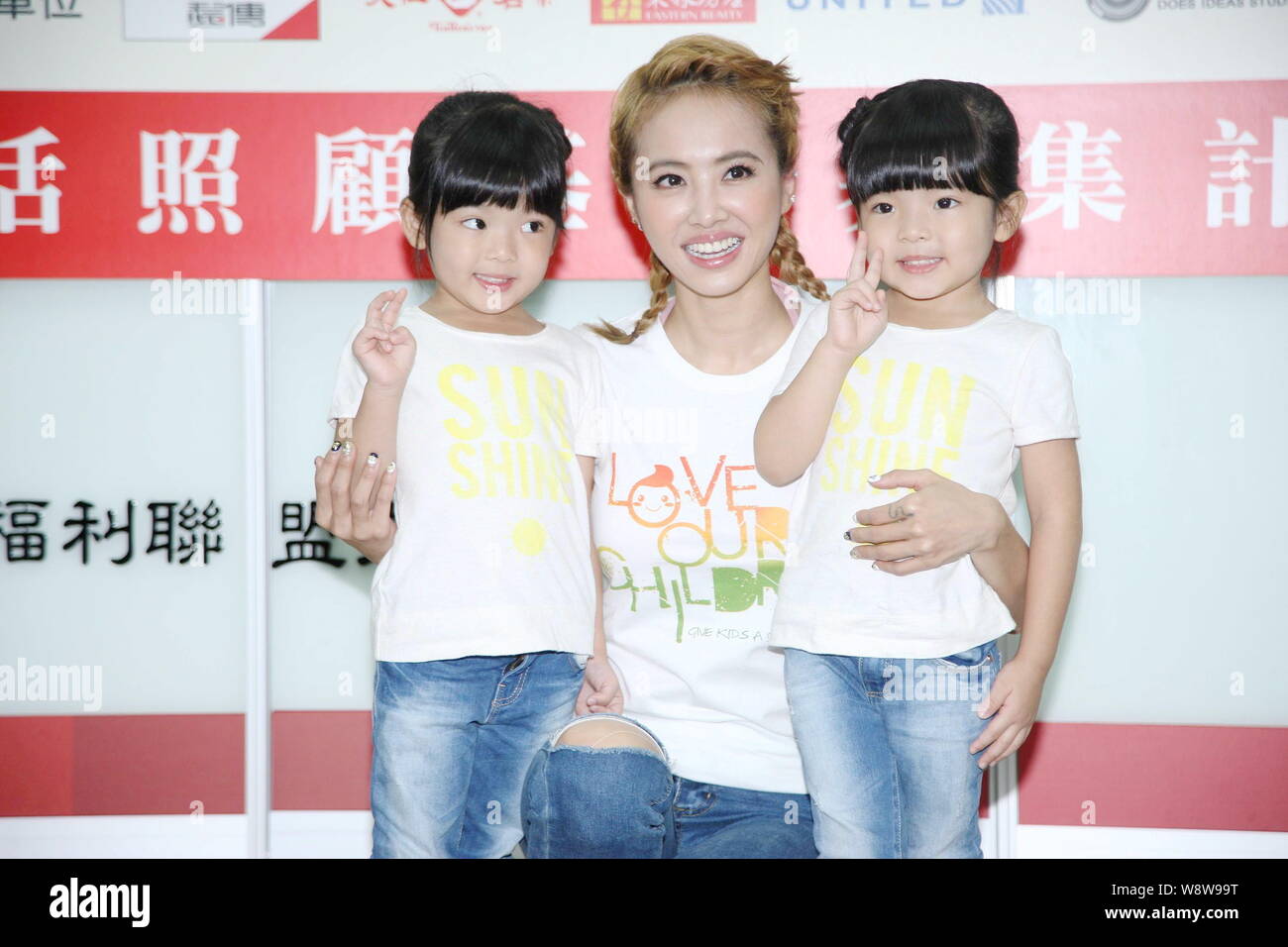 Taiwanese singer Jolin Tsai poses with a pair of young twin girls at a press conference for a ...