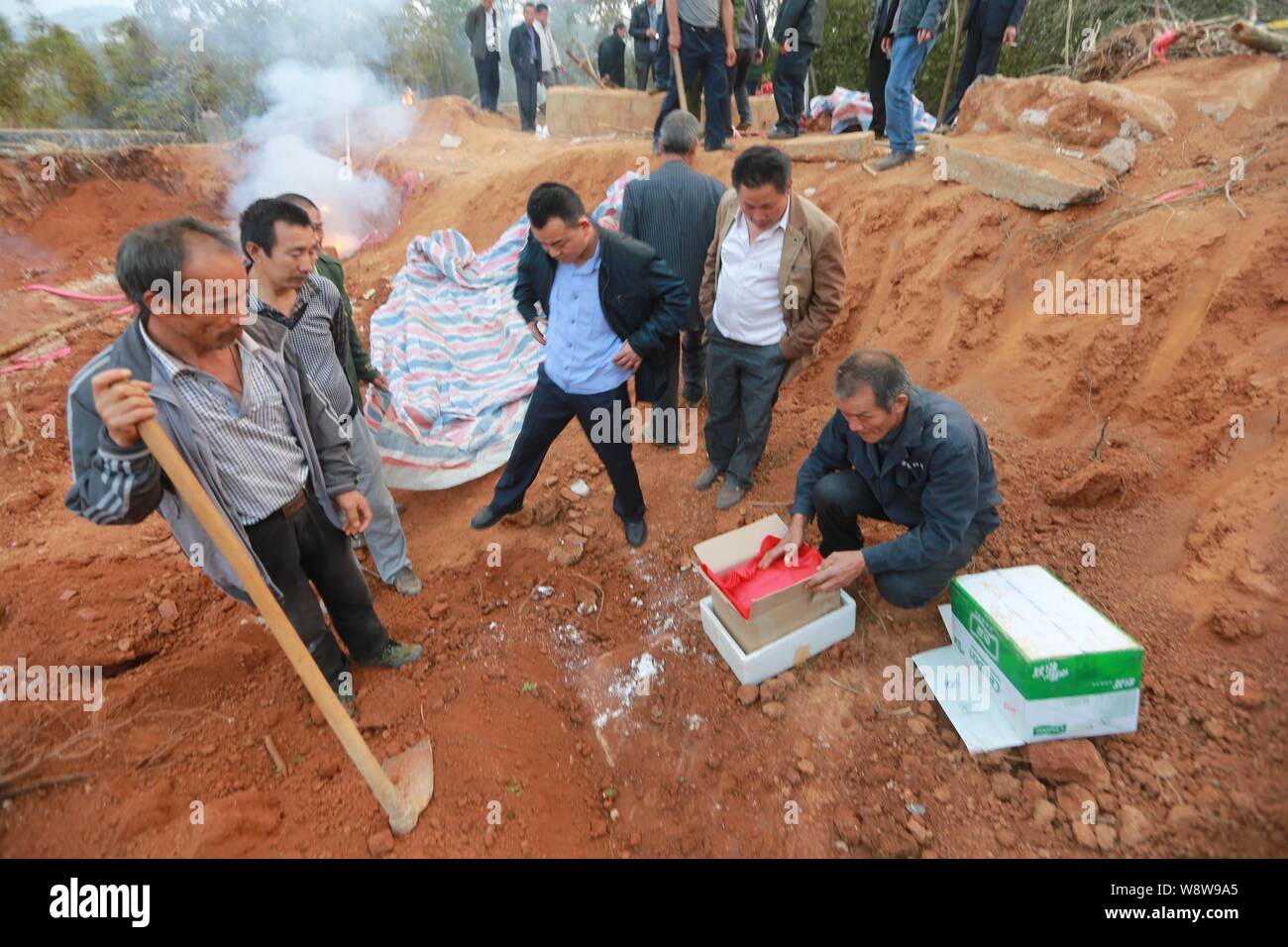 Liu Guoping, right, a descendant of the entombed, keeps the remains ...