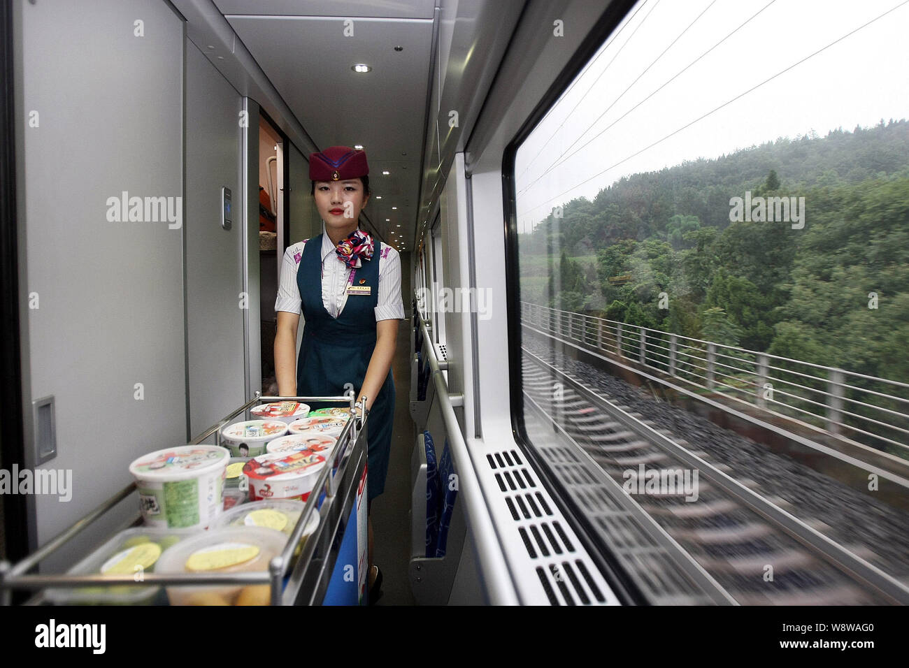 A train attendant serves food on the D628 CRH (China Railway High-speed ...