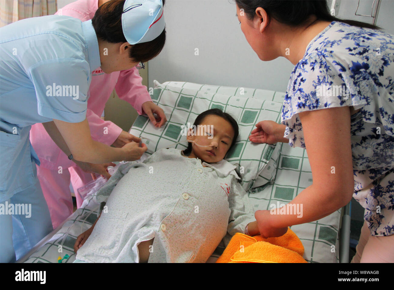 Nurses examine 12-year-old girl Han Bingbing, center, who suffered from ...