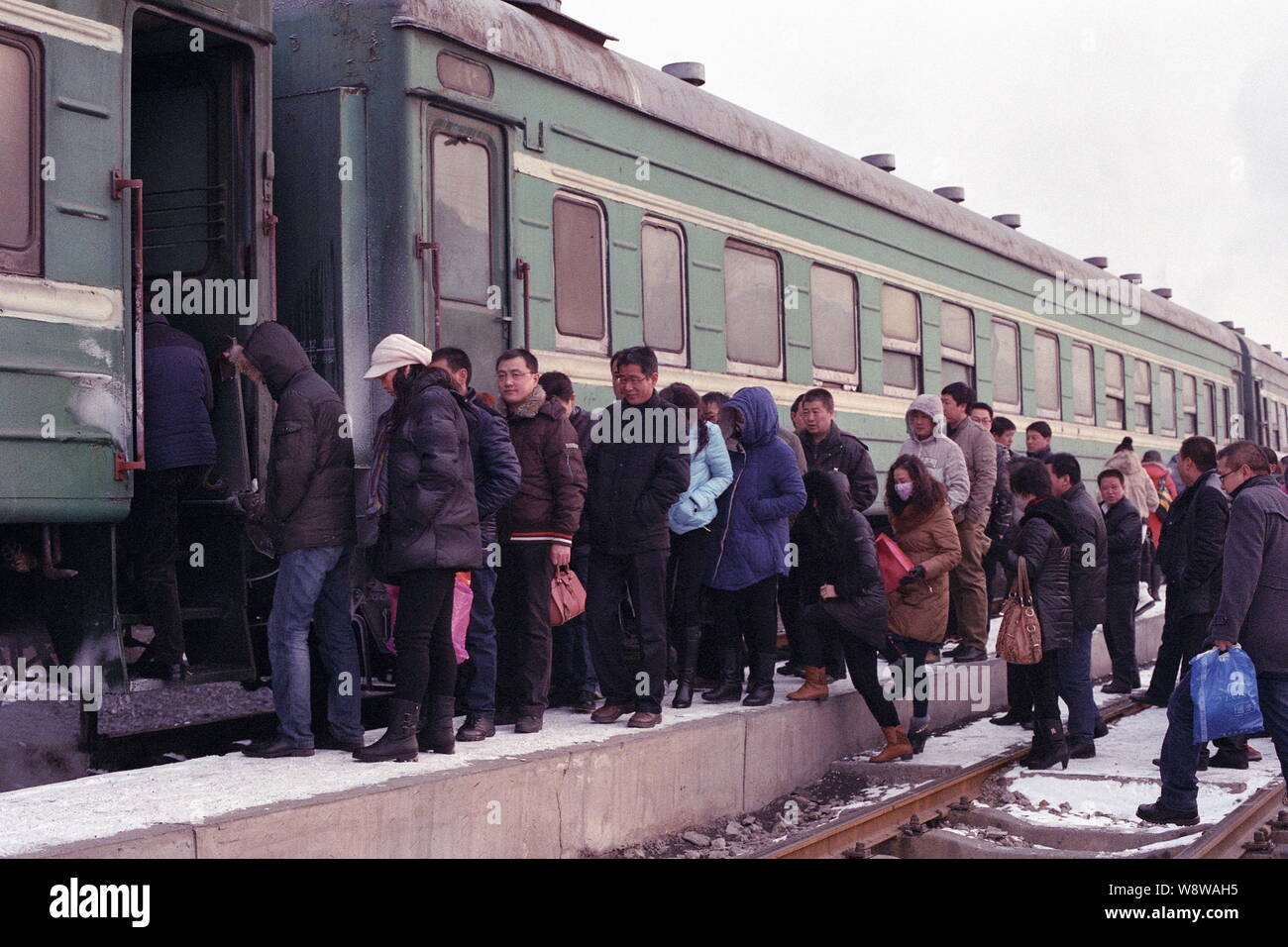 --FILE--Passengers queue up to board a "green-skin" train at the ...