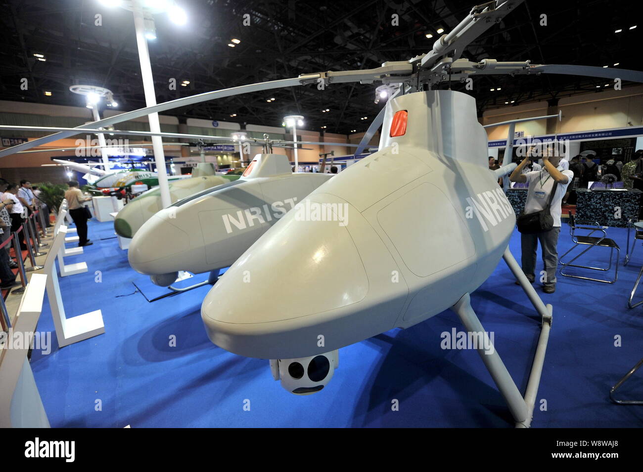 Visitors look at drones on display at the stand of NRIST (Nanjing ...