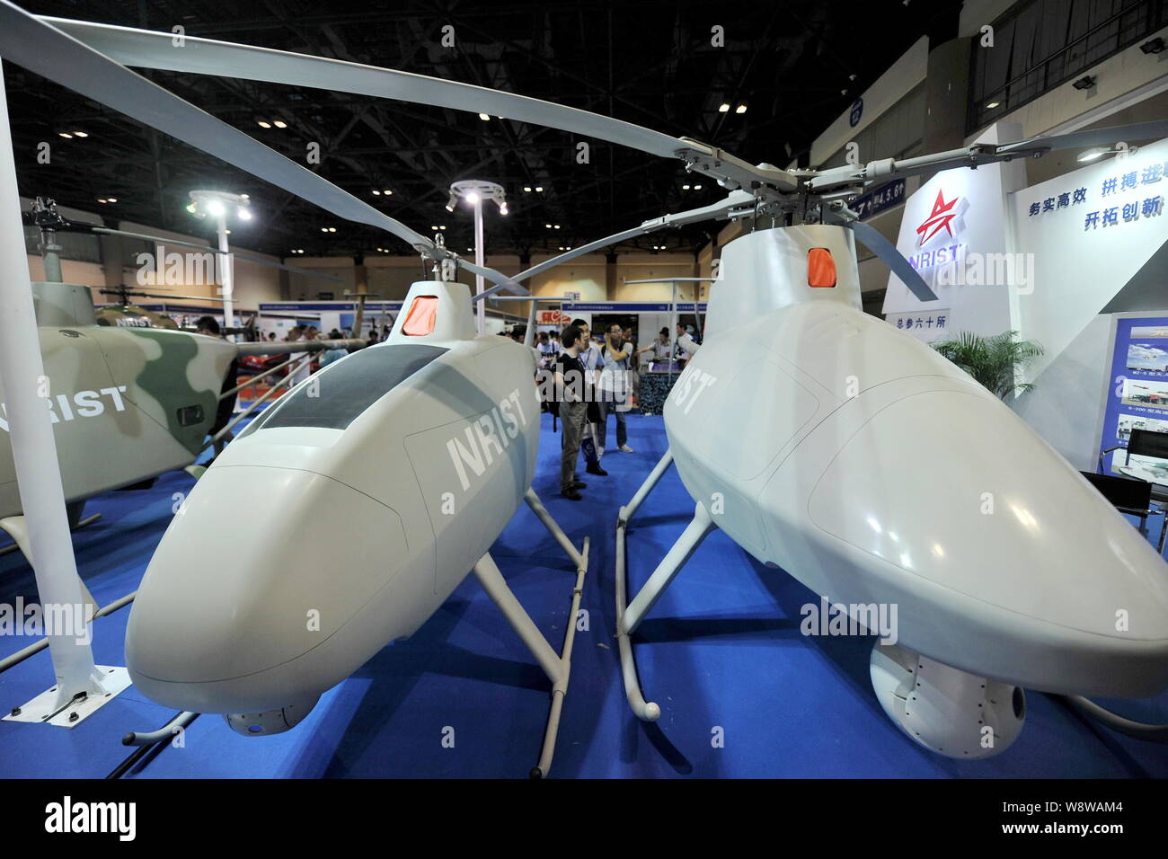 Visitors look at drones on display at the stand of NRIST (Nanjing ...