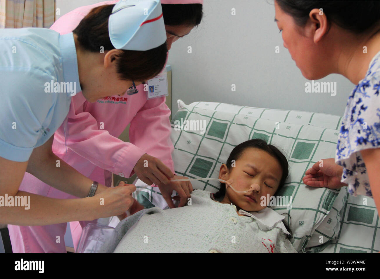 Nurses examine 12-year-old girl Han Bingbing, center, who suffered from ...