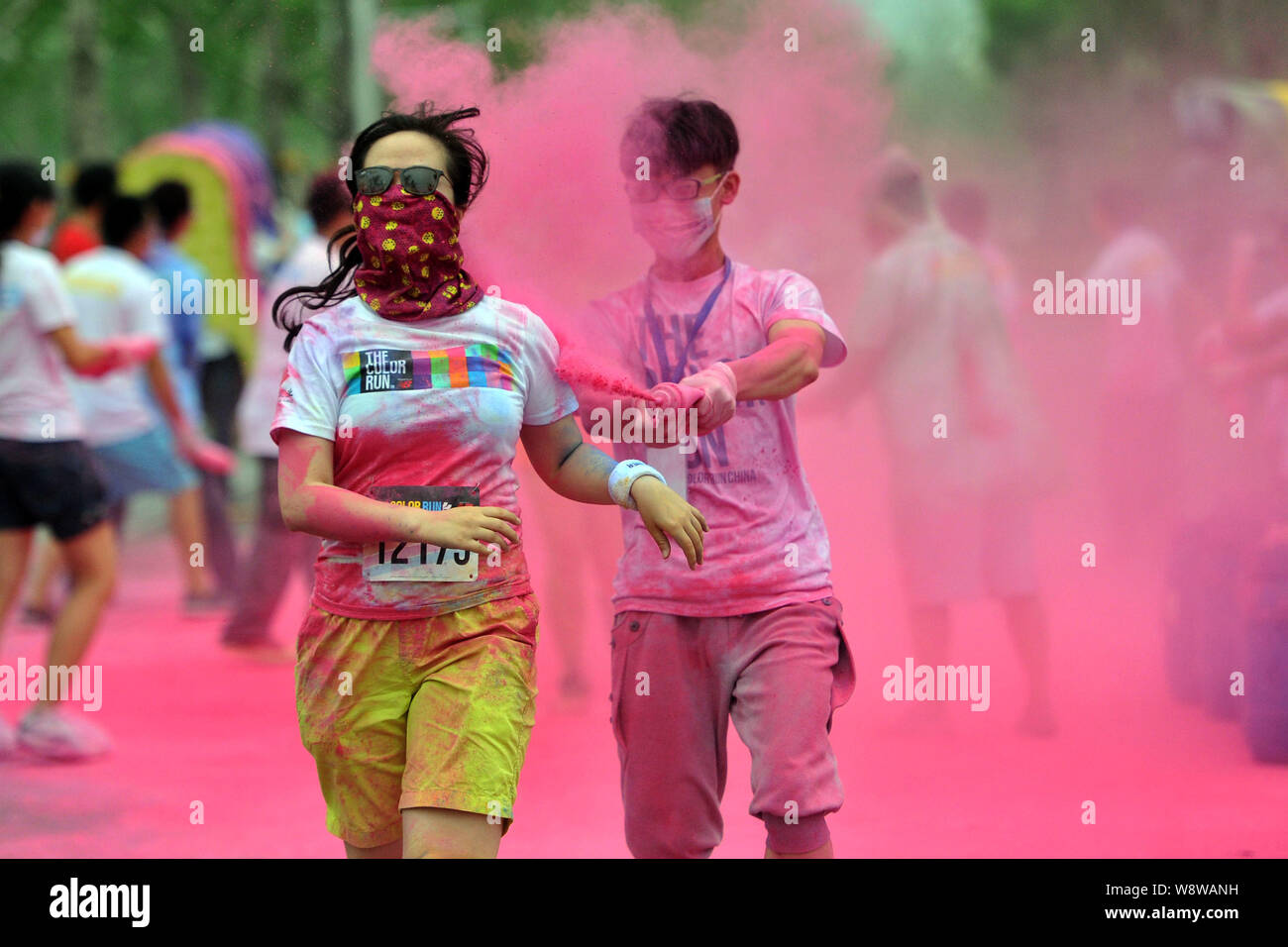 A participant is sprayed by a staff member with colored powder as she ...