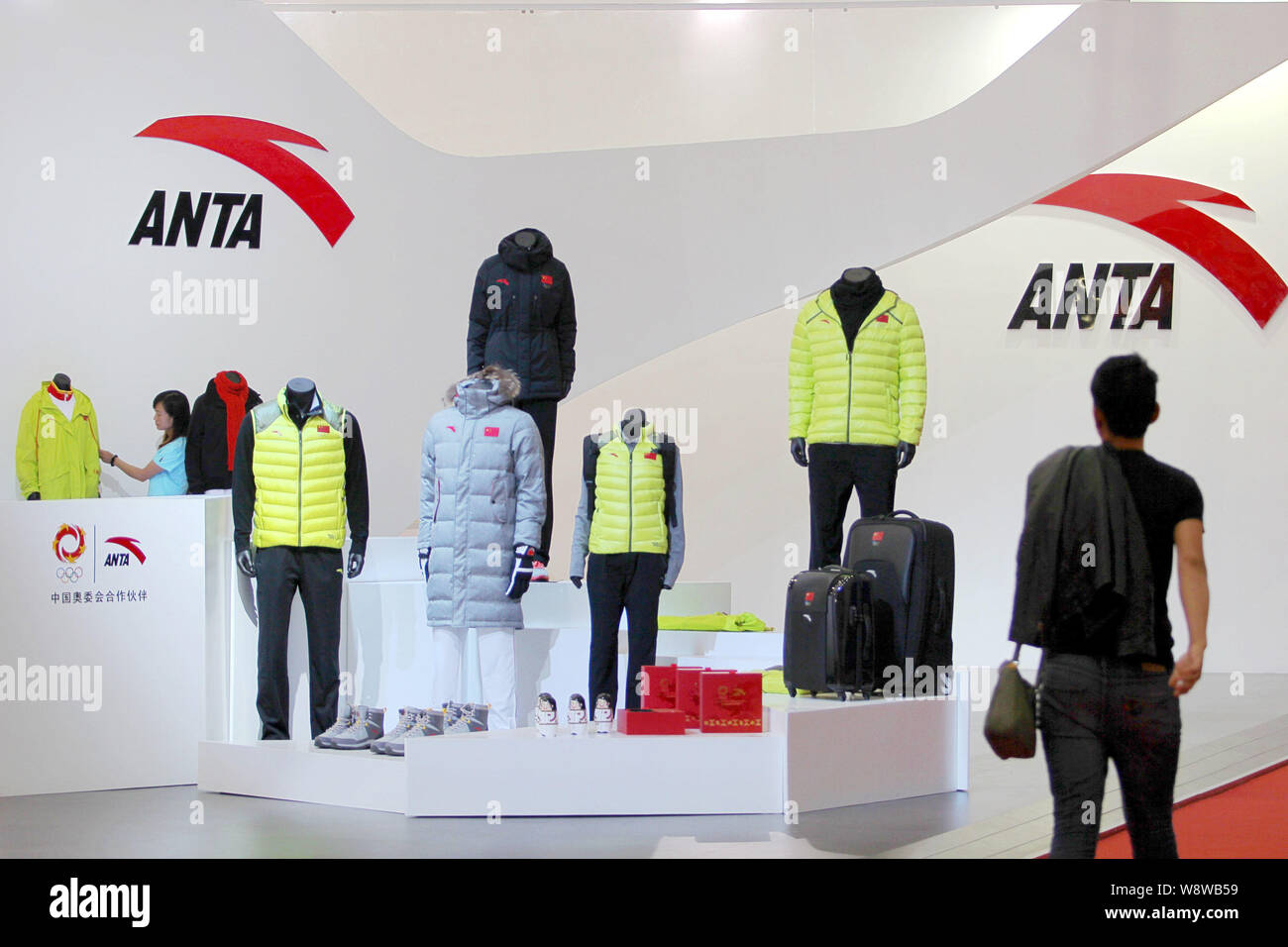 --FILE--A visitor walks past down coats of Anta on display during an ...