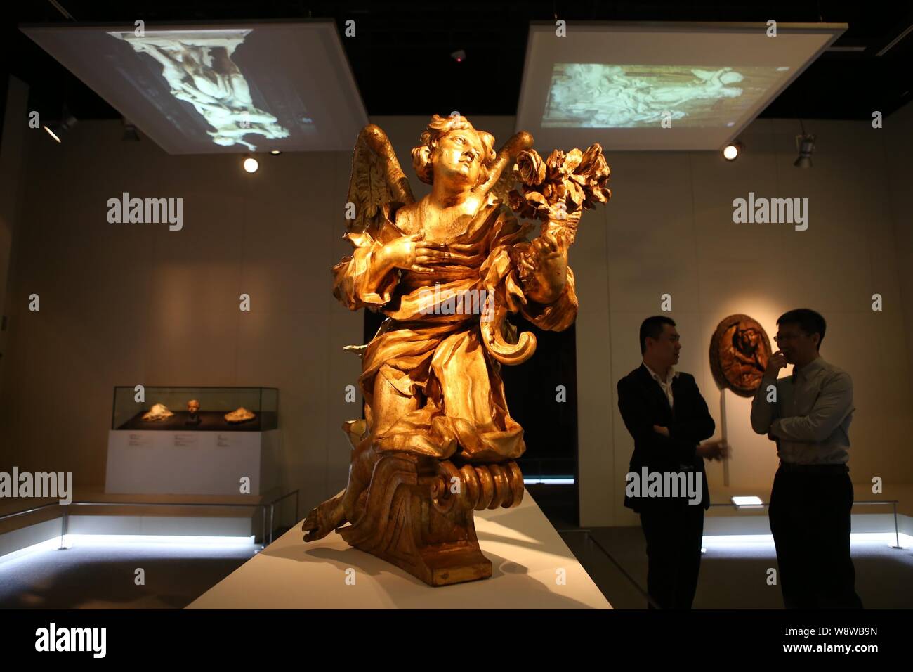 Visitors talk next to a Baroque sculpture one day before the opening of ...