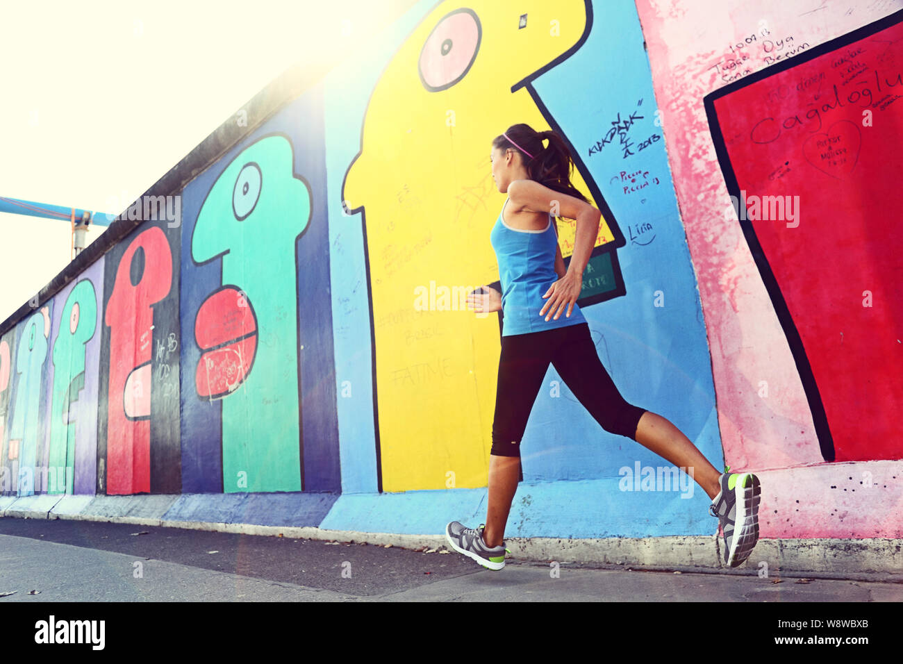 Running woman jogging sightseeing and sightrunning by Berlin Wall ...