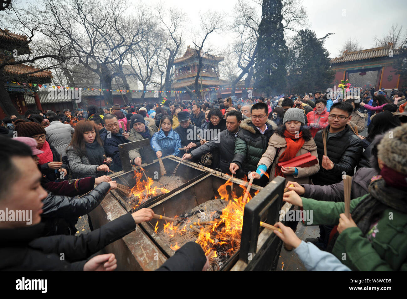 Chinese worshippers burn incense sticks to pray for good fortune and ...