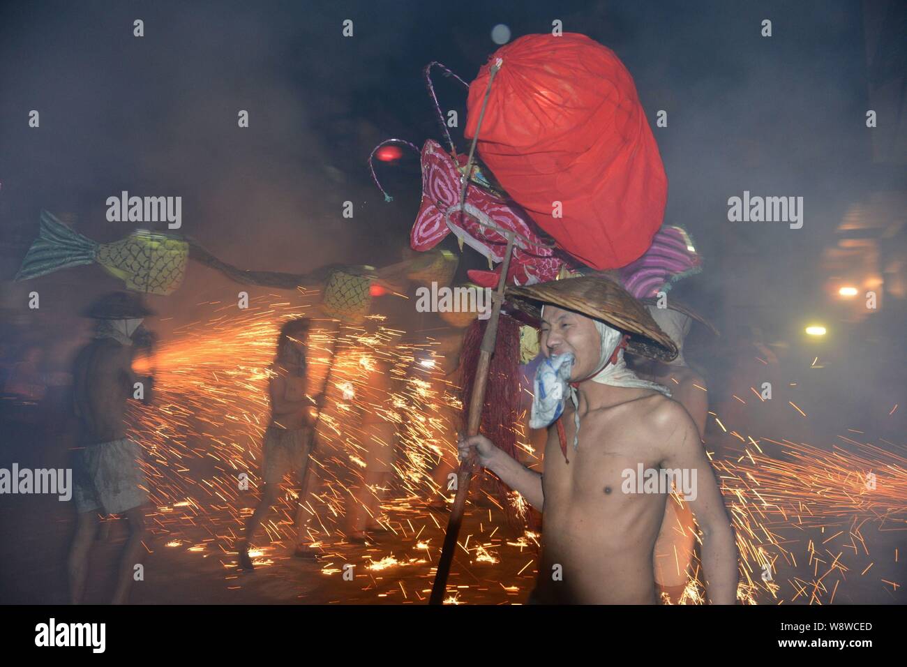 Chinese entertainers perform a fire dragon dance in sparks of fireworks ...
