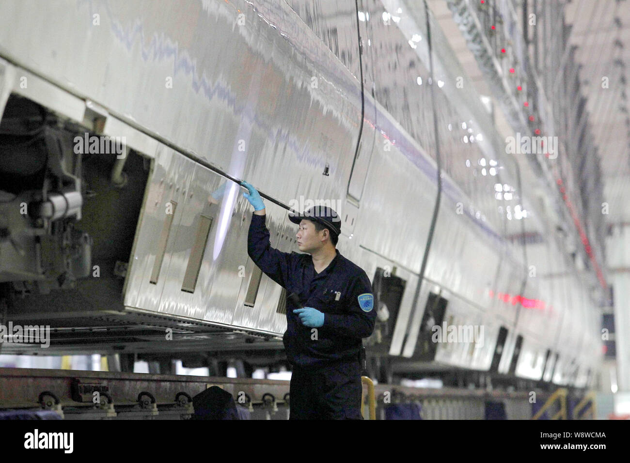 A Chinese worker examines a CRH (China Railway High-speed) train at a ...
